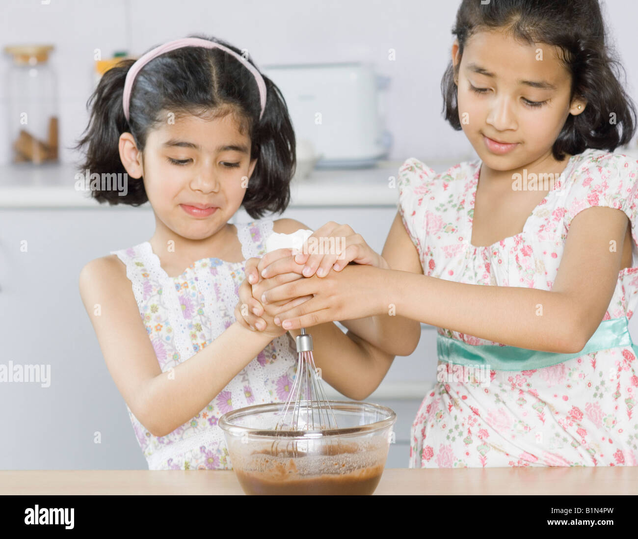 Close-up of two sisters preparing food in the kitchen Stock Photo - Alamy