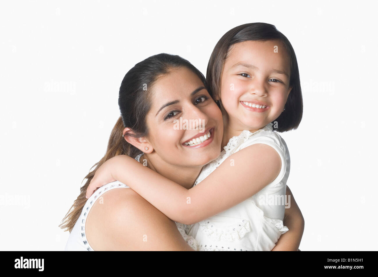 Portrait of a young woman hugging her daughter and smiling Stock Photo ...