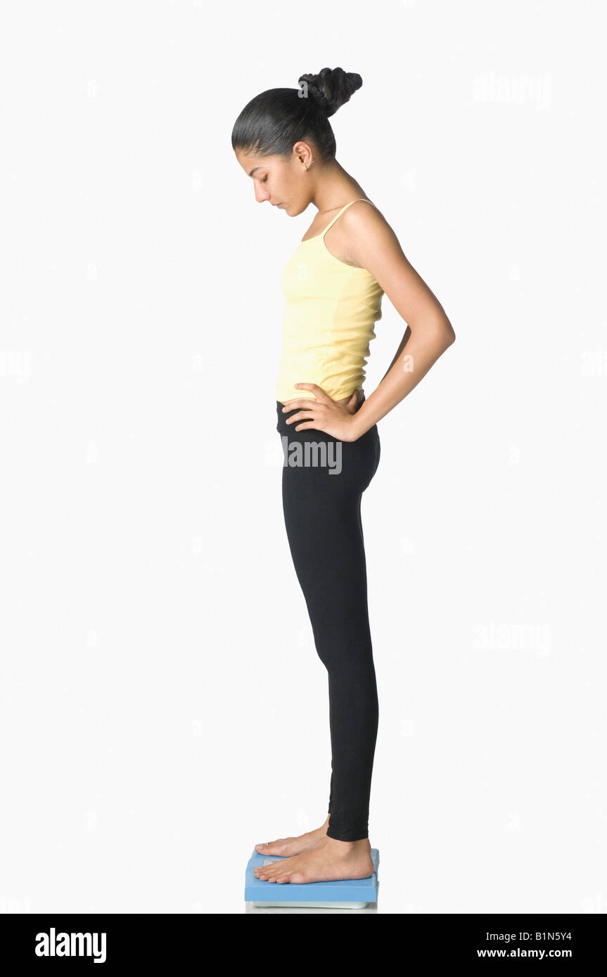 Side profile of a young woman standing on a weighing scale Stock Photo ...