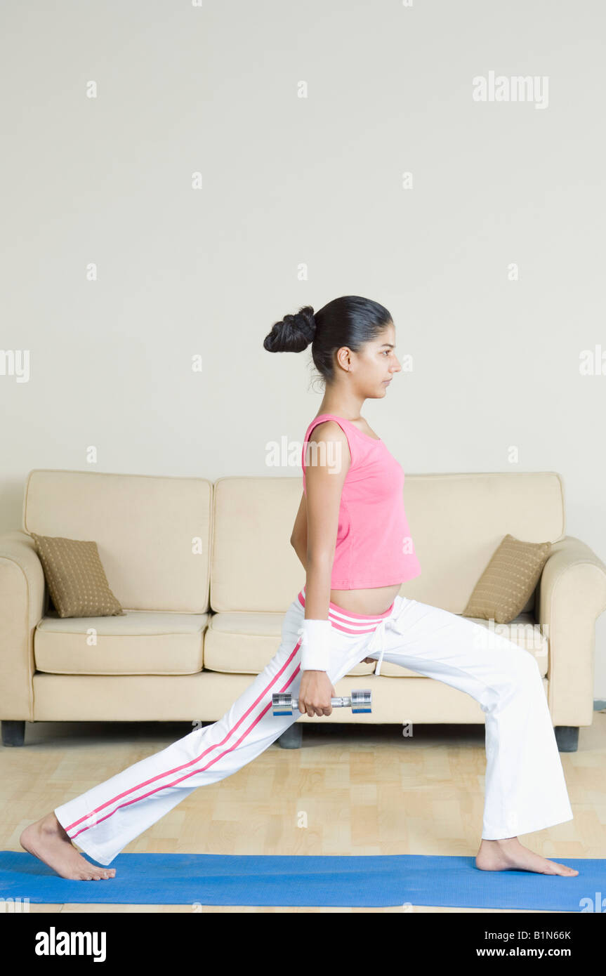 Side profile of a young woman exercising on an exercise mat Stock Photo ...