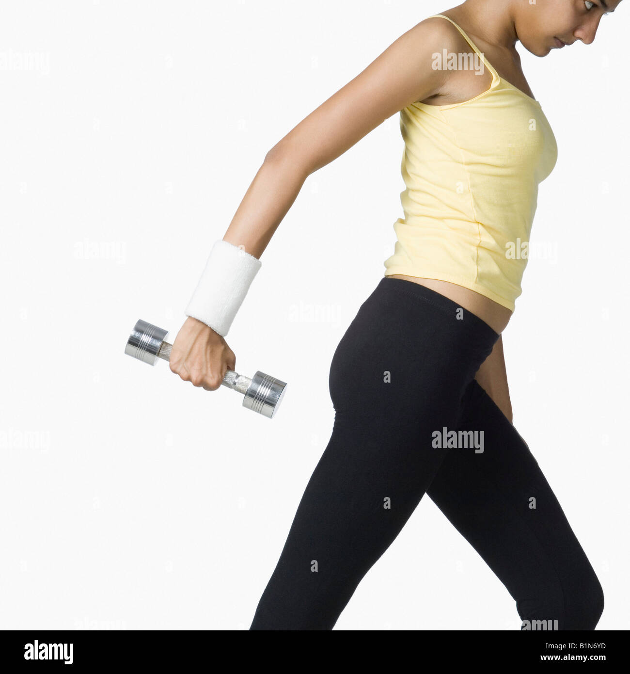 Side profile of a young woman exercising with a dumbbell Stock Photo ...