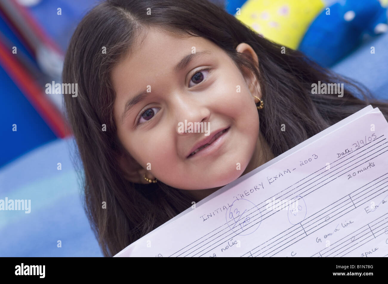 Portrait of a girl showing her answer sheet and smiling Stock Photo - Alamy