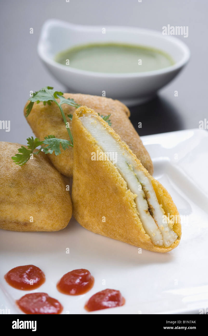 Close-up of three bread pakoras with sauce in a tray Stock Photo - Alamy