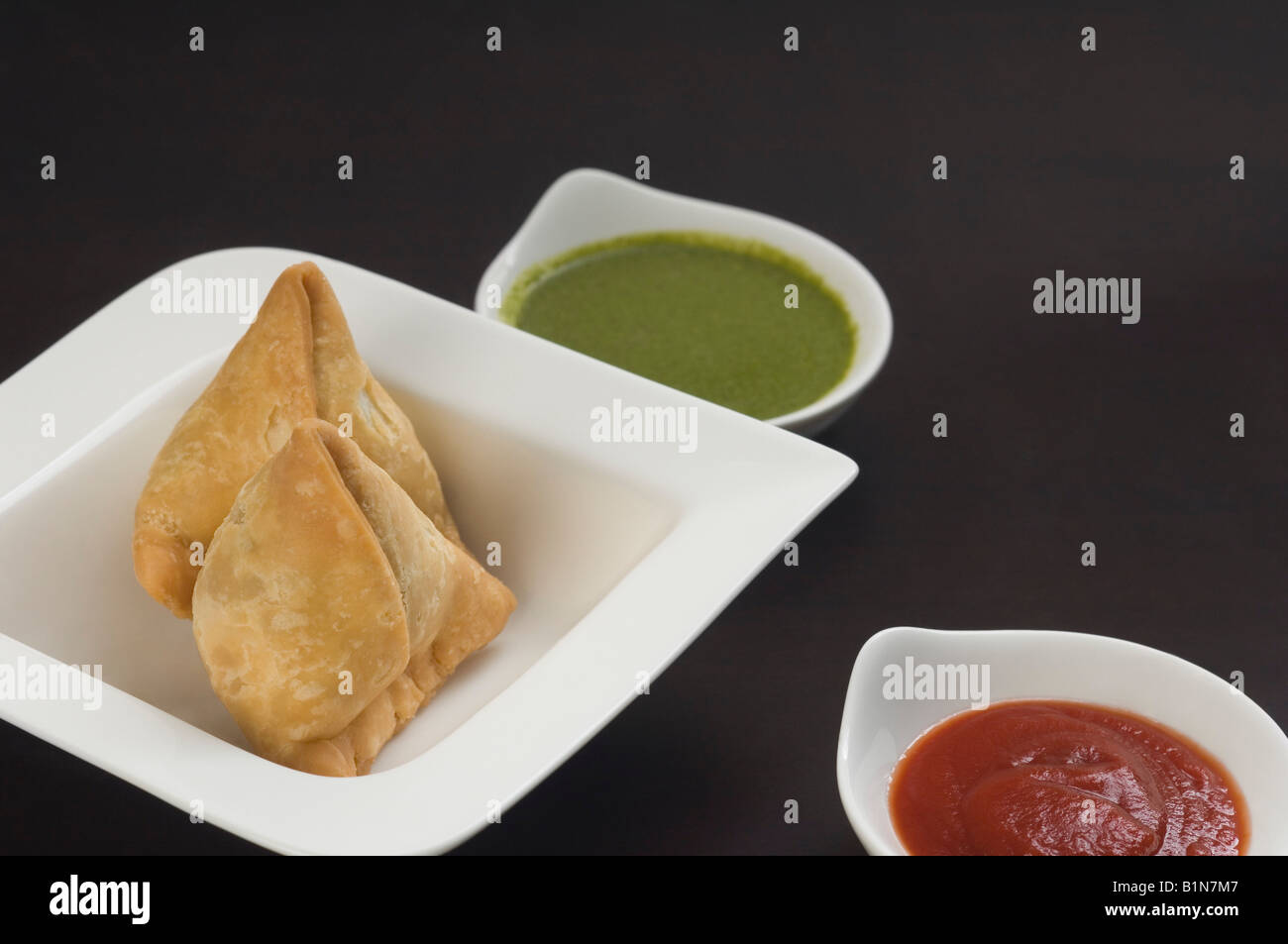 Close-up of two samosas with sauce Stock Photo - Alamy