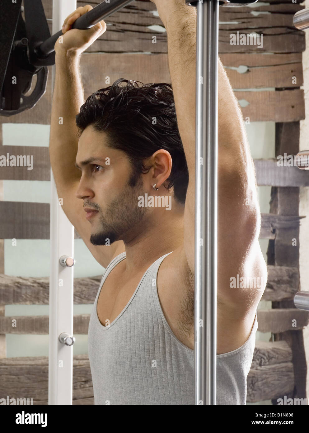 Side profile of a young man exercising in a gym Stock Photo - Alamy