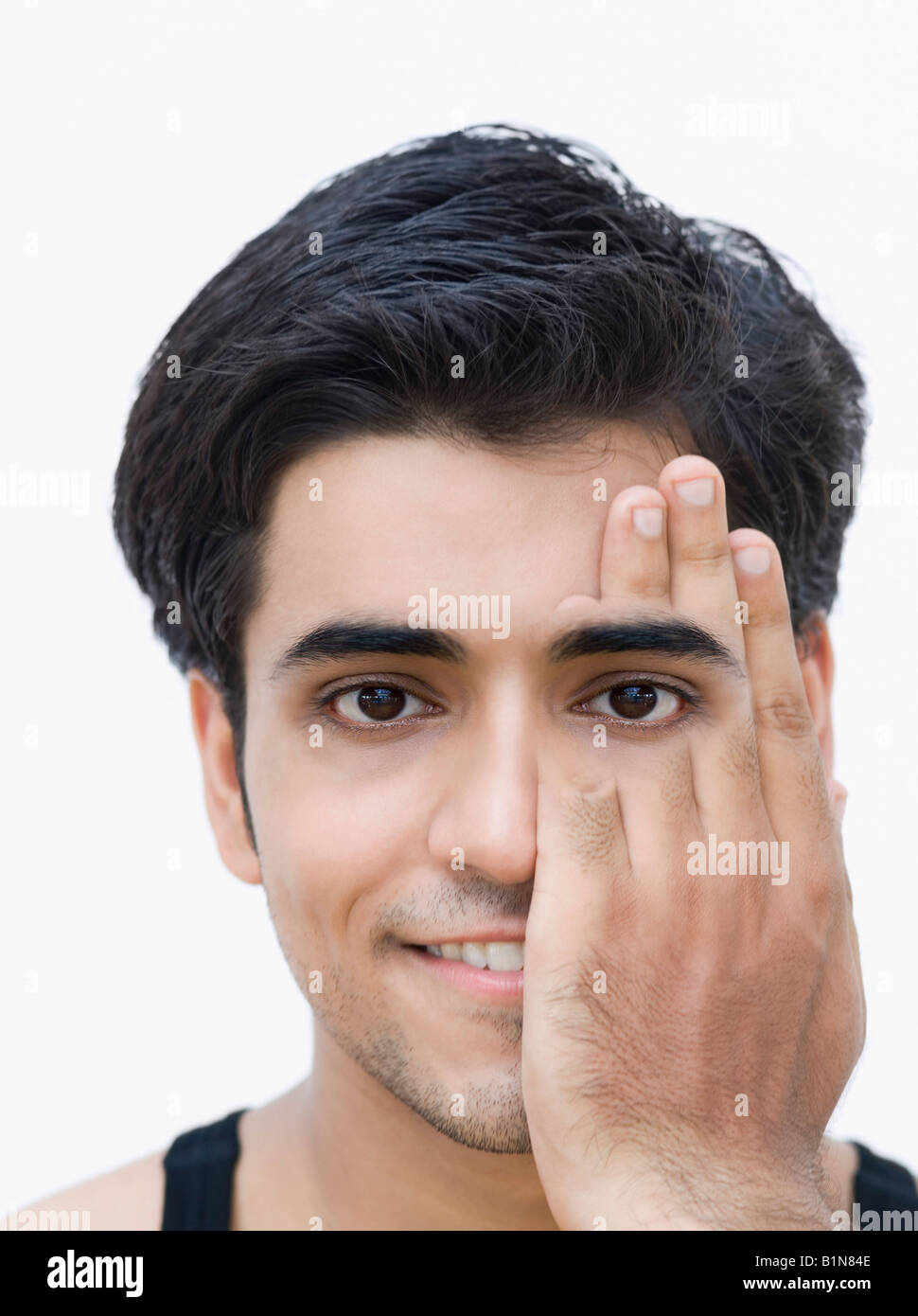 Portrait of a young man covering his one eye with his hand Stock Photo ...