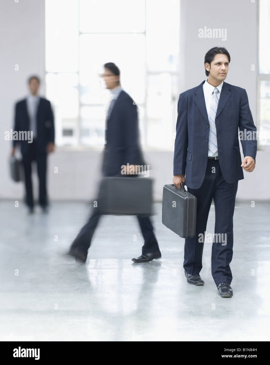 Three businessmen walking in an office Stock Photo - Alamy