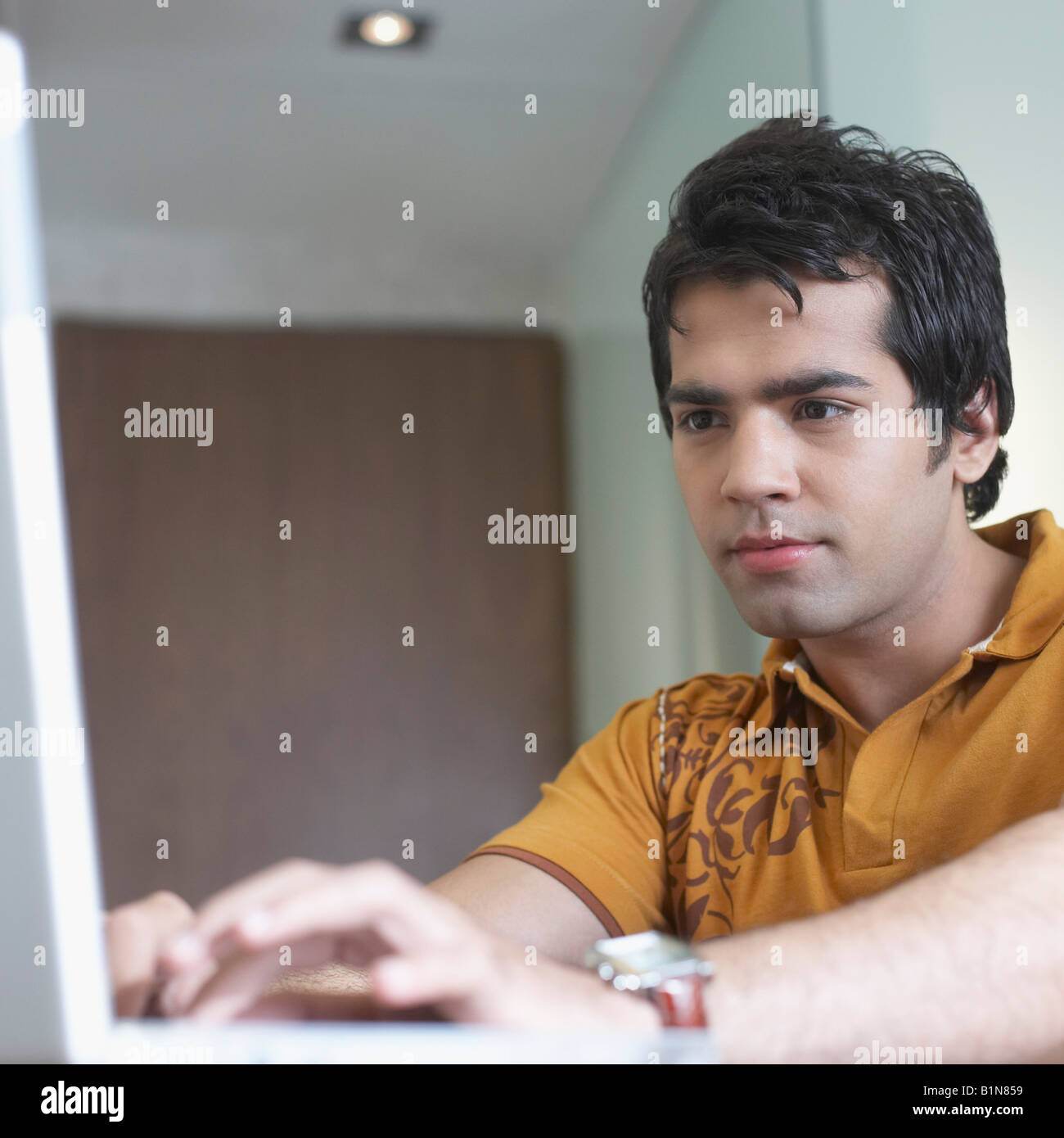 Young man using a laptop Stock Photo - Alamy