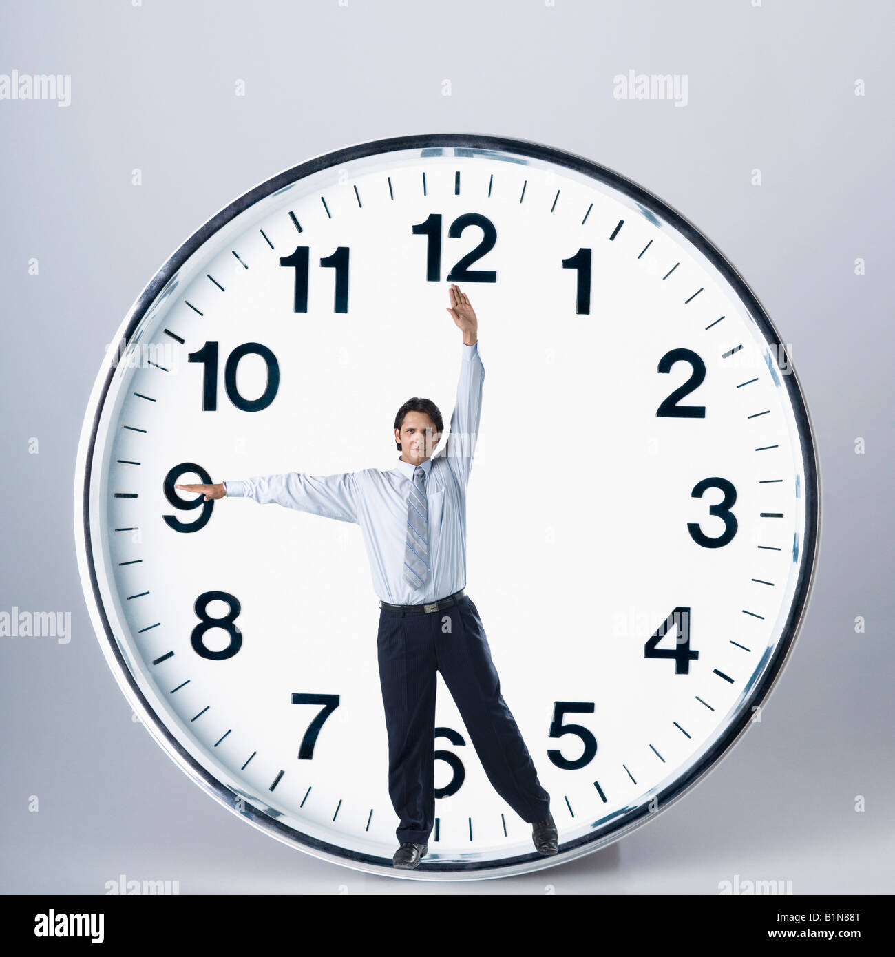Businessman performing in a clock Stock Photo - Alamy