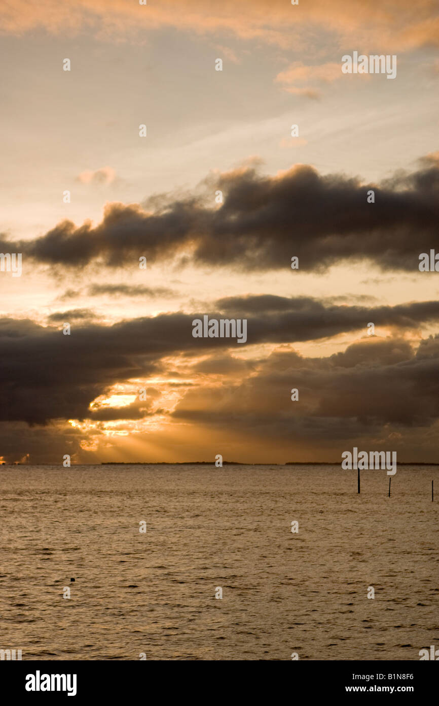 sunset with bright sun rays over ocean Stock Photo - Alamy