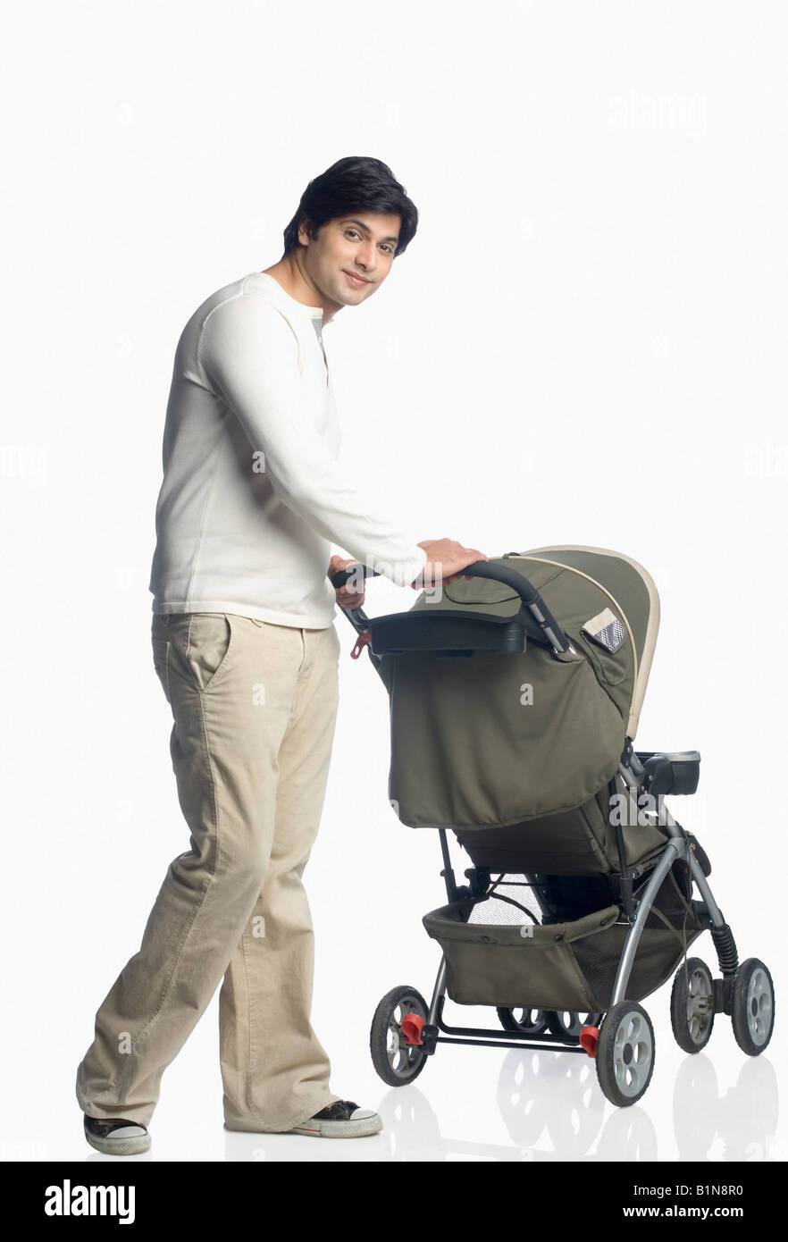 Young man holding a baby stroller Stock Photo - Alamy