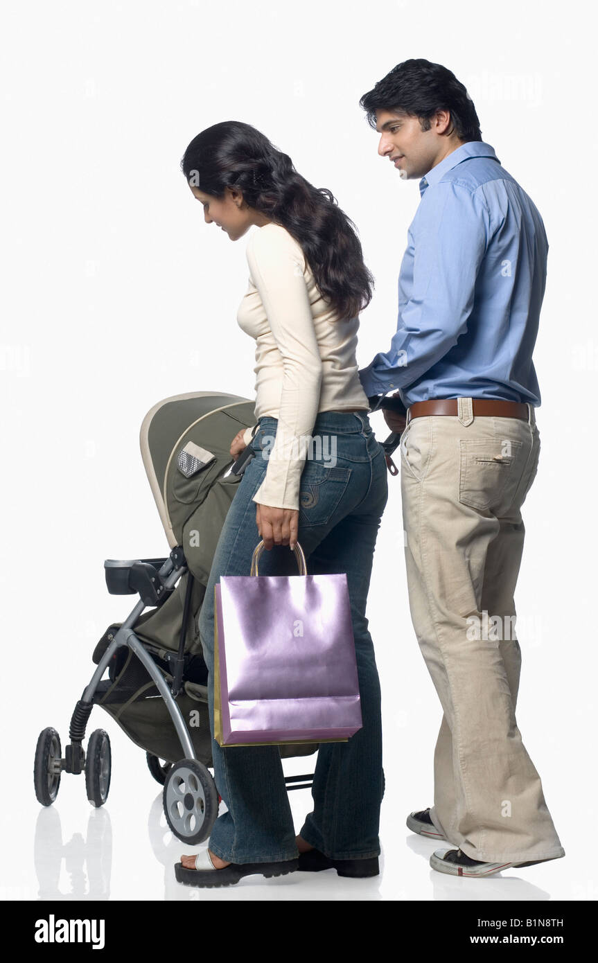 Side profile of a couple holding a baby stroller Stock Photo - Alamy