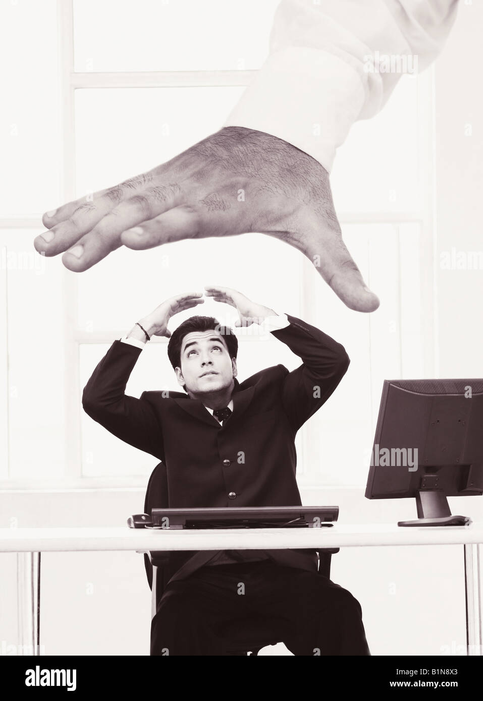 Businessman being crushed under a human hand Stock Photo - Alamy