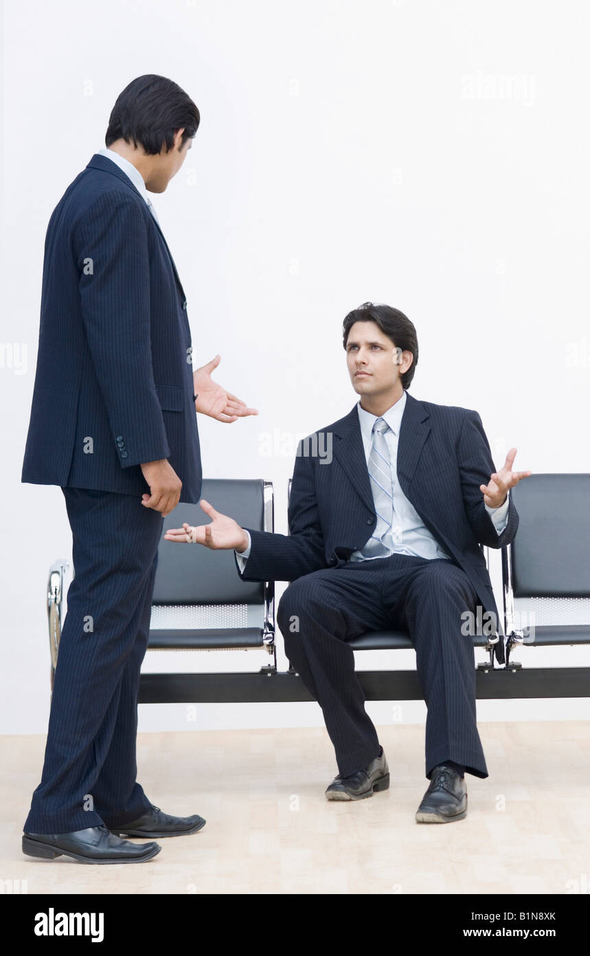 Two businessmen talking to each other and gesturing Stock Photo - Alamy