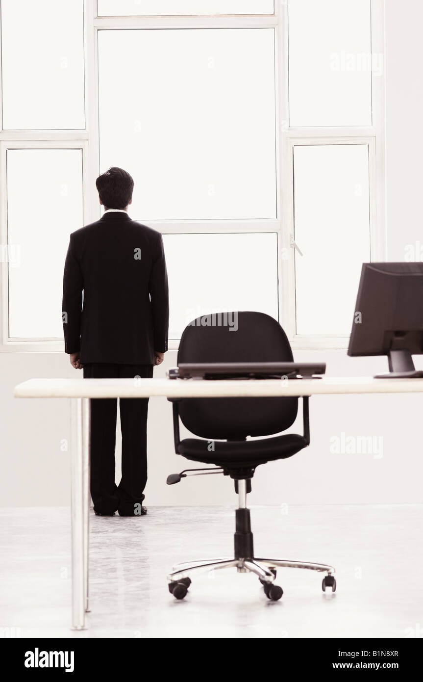 Rear view of a businessman standing in an office Stock Photo - Alamy