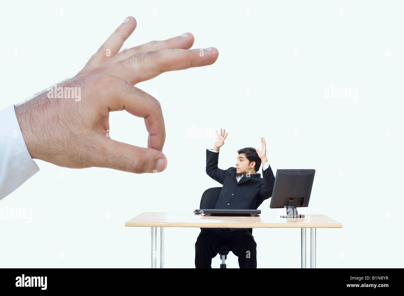 Person's hand flicking a businessman sitting with his arms raised Stock ...