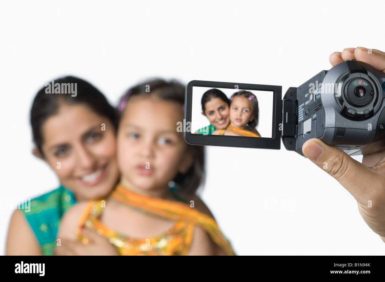 Close-up of a person's hand filming a young woman and her daughter with ...