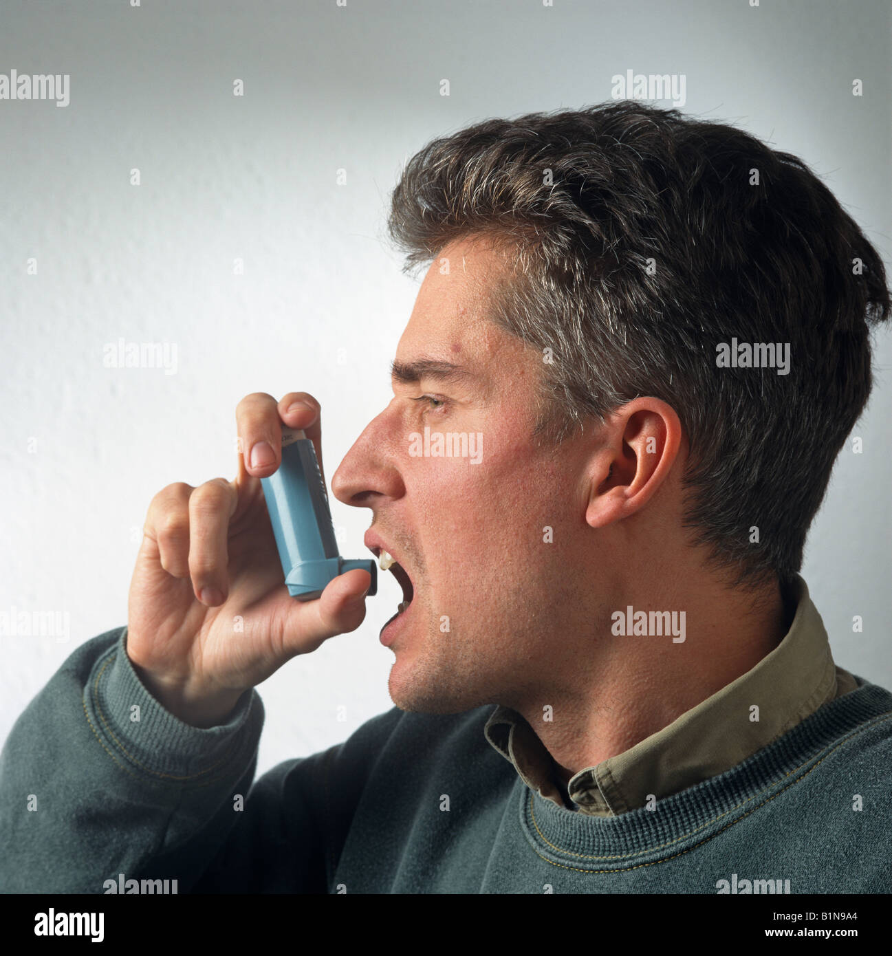 Man using inhaler to relieve asthma, UK. Model released Stock Photo - Alamy