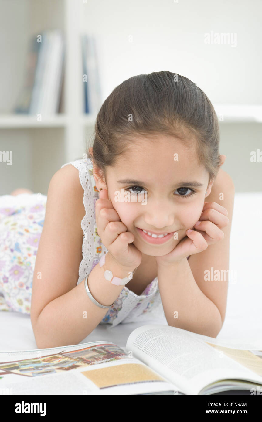 Portrait of a girl reading a book and smiling Stock Photo - Alamy