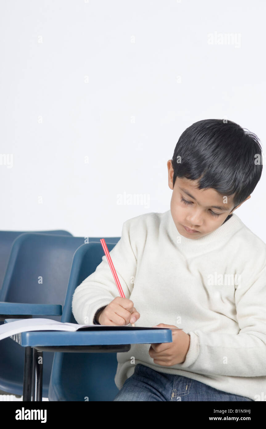 Schoolboy sitting in a classroom and studying Stock Photo - Alamy