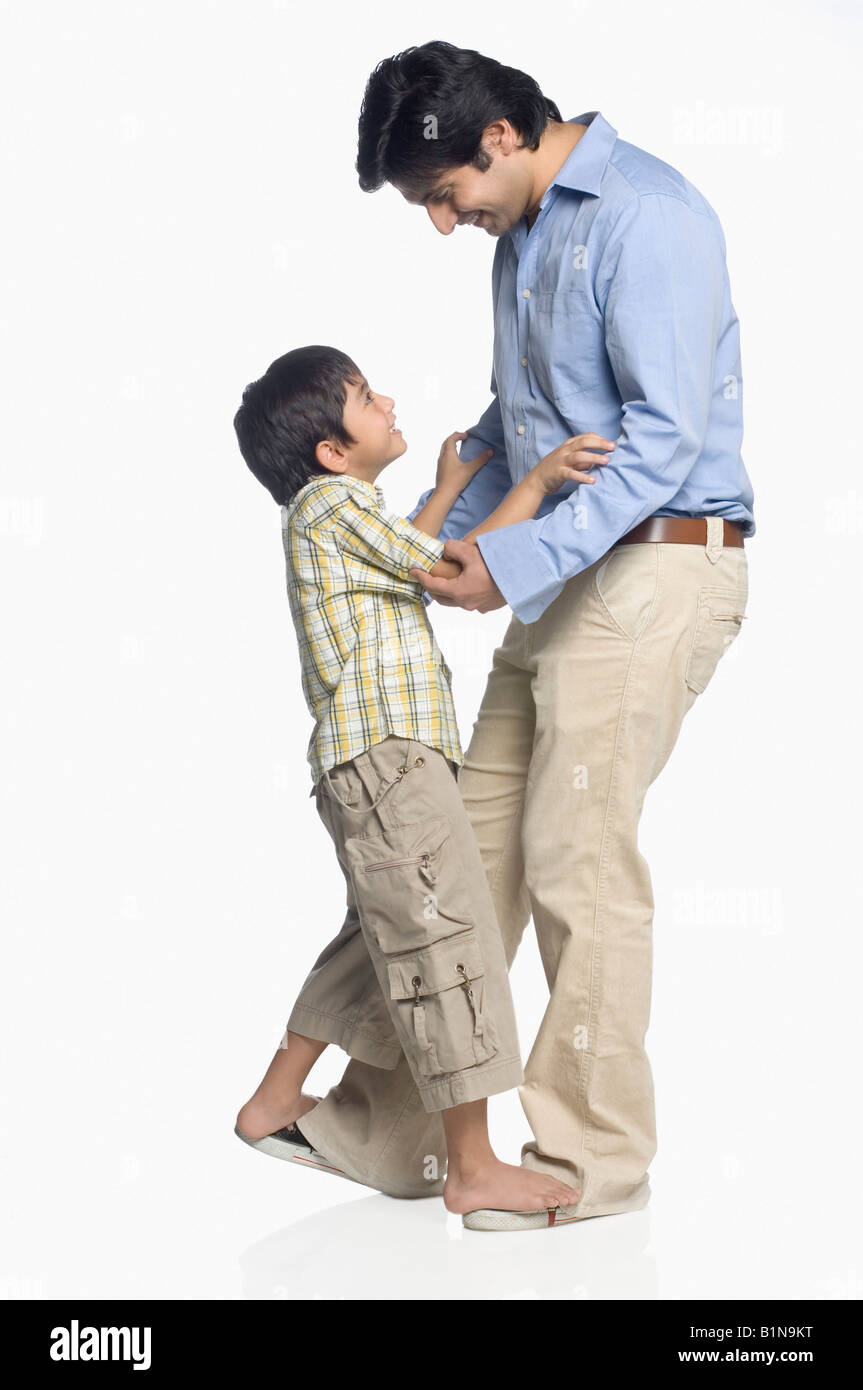 Boy standing on his father's feet Stock Photo - Alamy