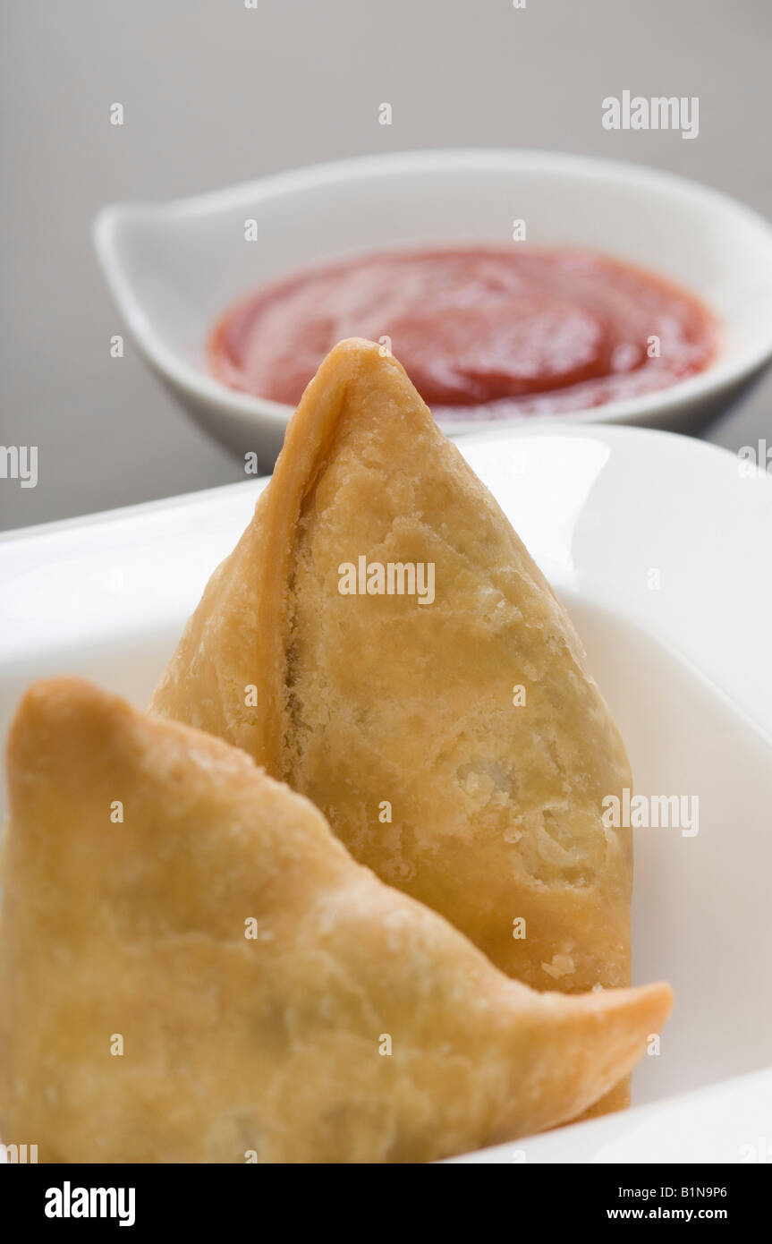 Close-up of two samosas with sauce Stock Photo - Alamy