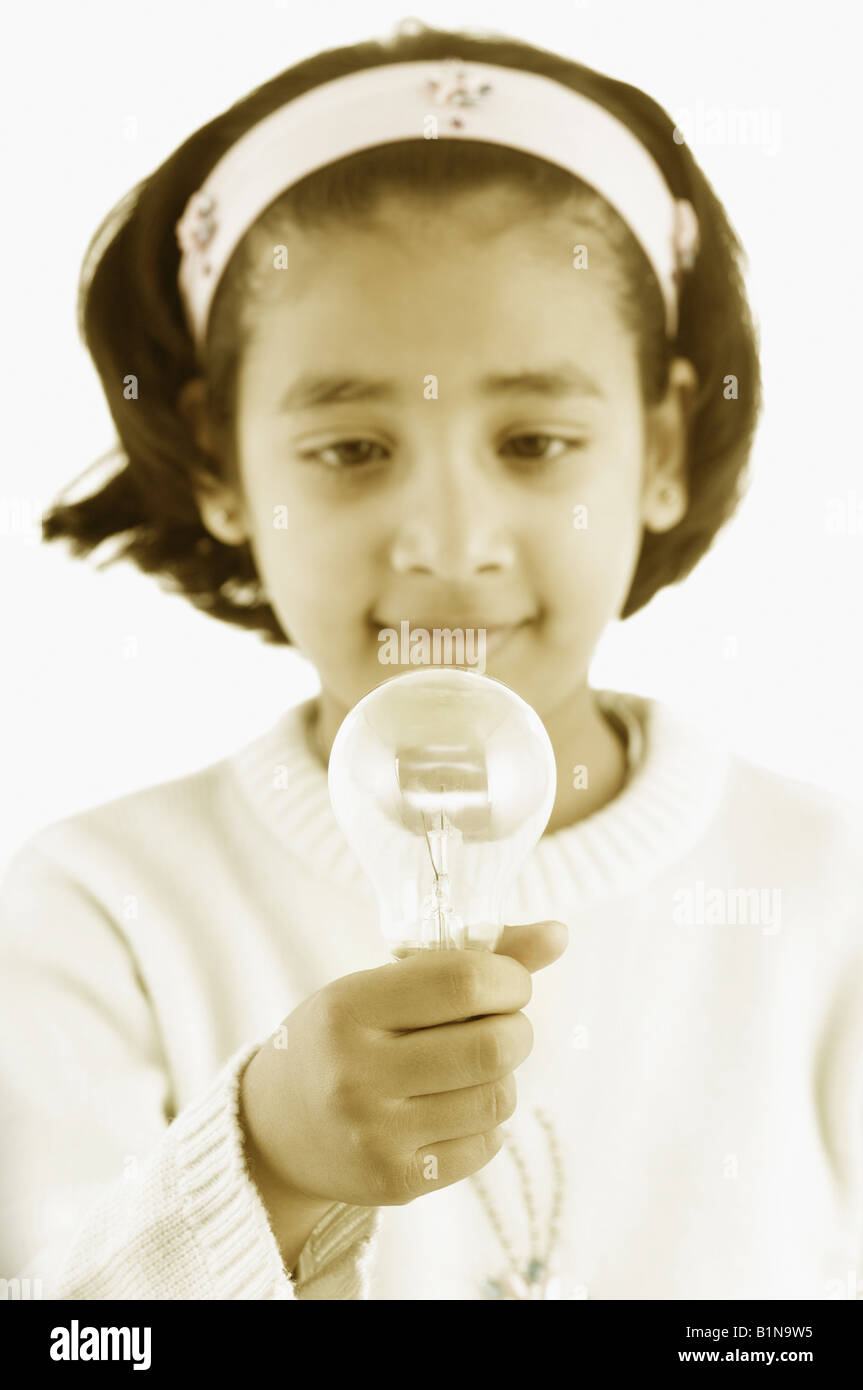 Girl holding a light bulb Stock Photo - Alamy