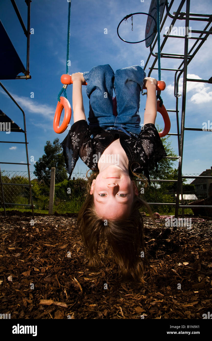 Young girl hanging upside down on a swing Stock Photo - Alamy