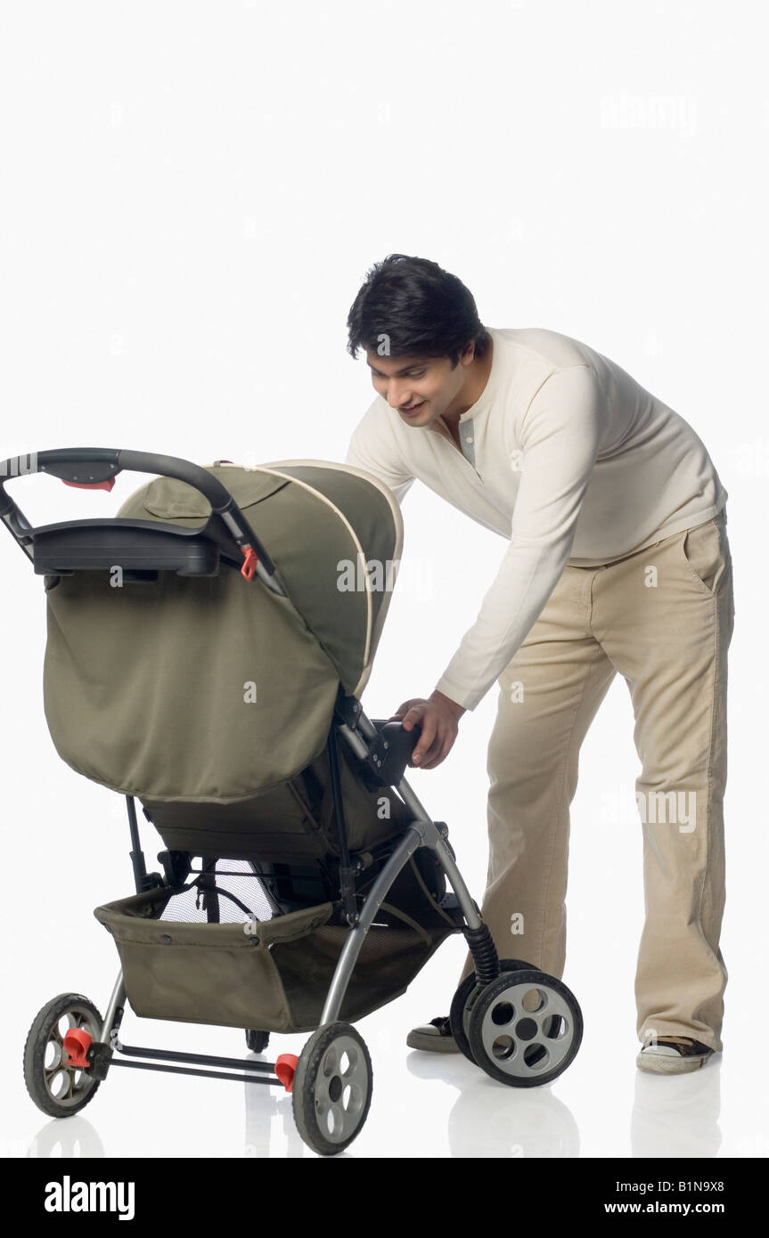 Young man holding a baby stroller Stock Photo - Alamy