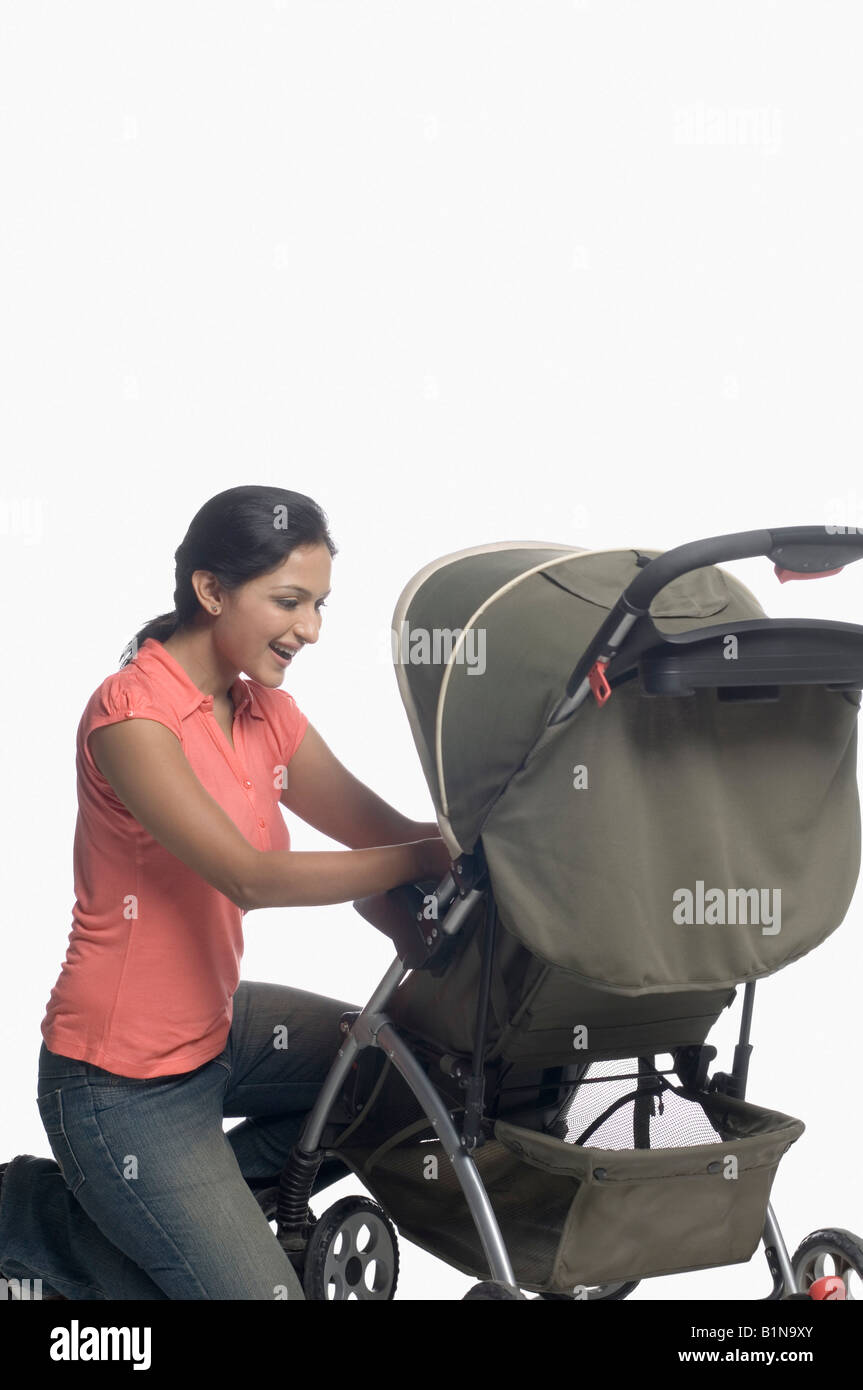 Mid adult woman holding a baby stroller Stock Photo - Alamy