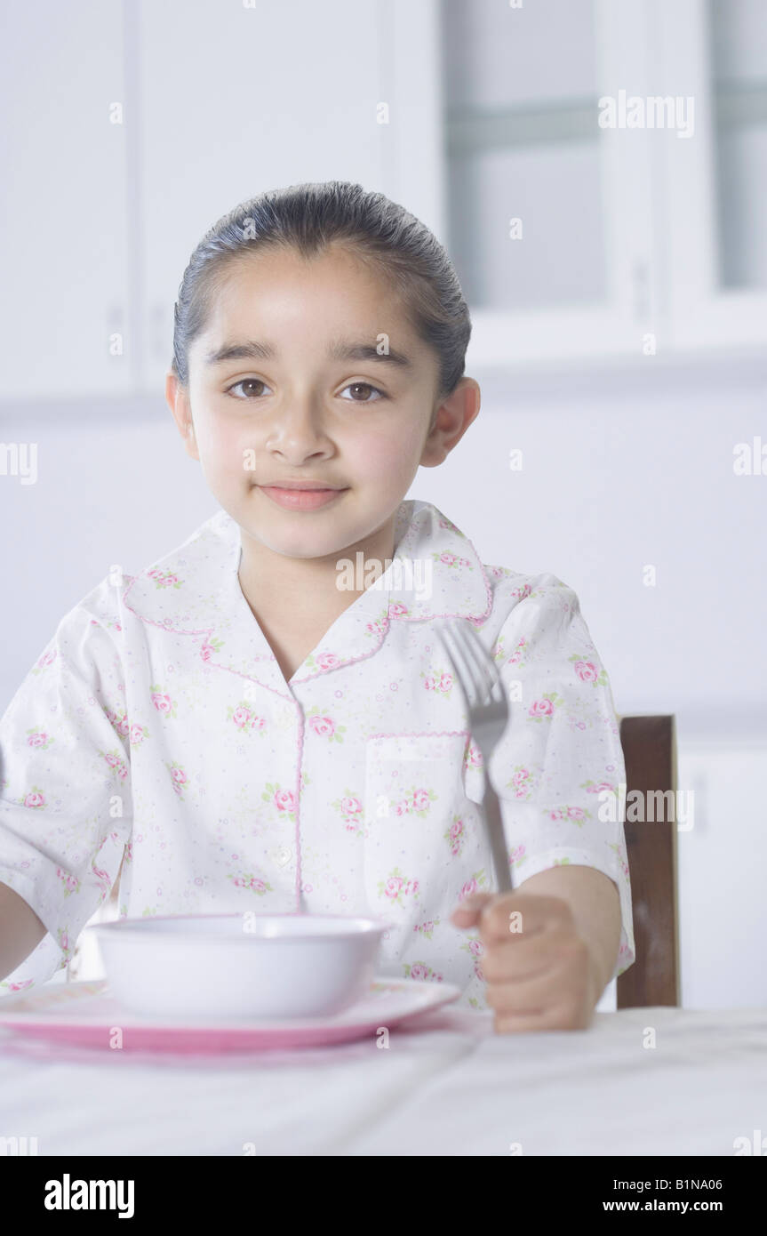 Close-up of a girl holding a fork at a dining table Stock Photo - Alamy
