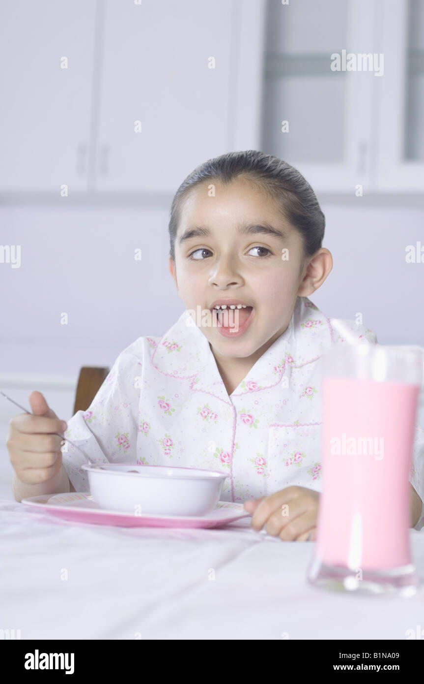 Girl eating food at a dining table Stock Photo - Alamy
