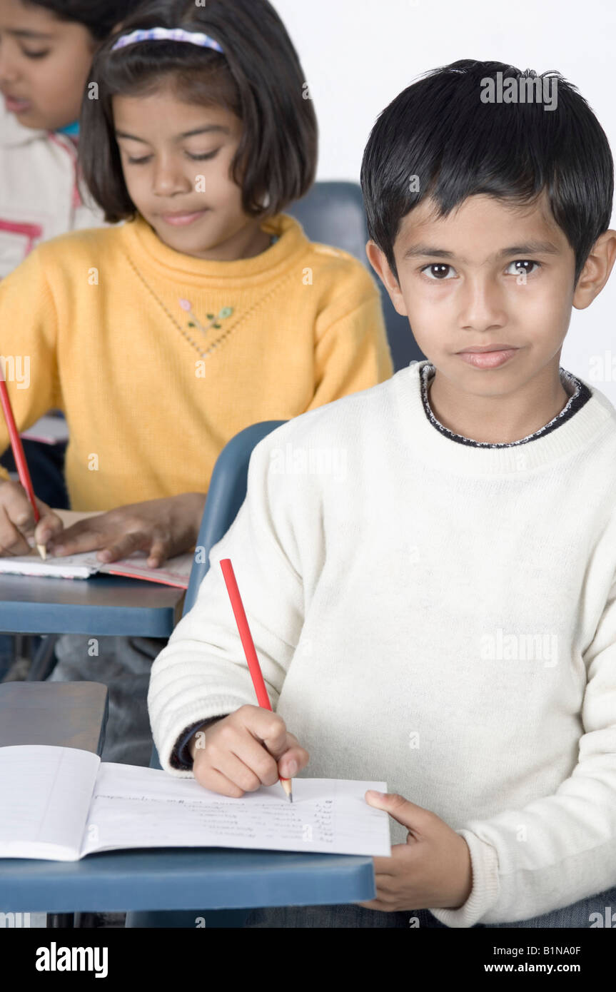 Three students sitting in a classroom and studying Stock Photo - Alamy