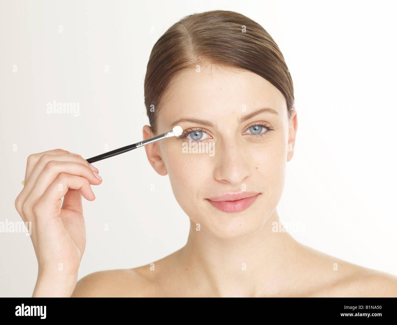 Woman with an eye shadow brush Stock Photo - Alamy