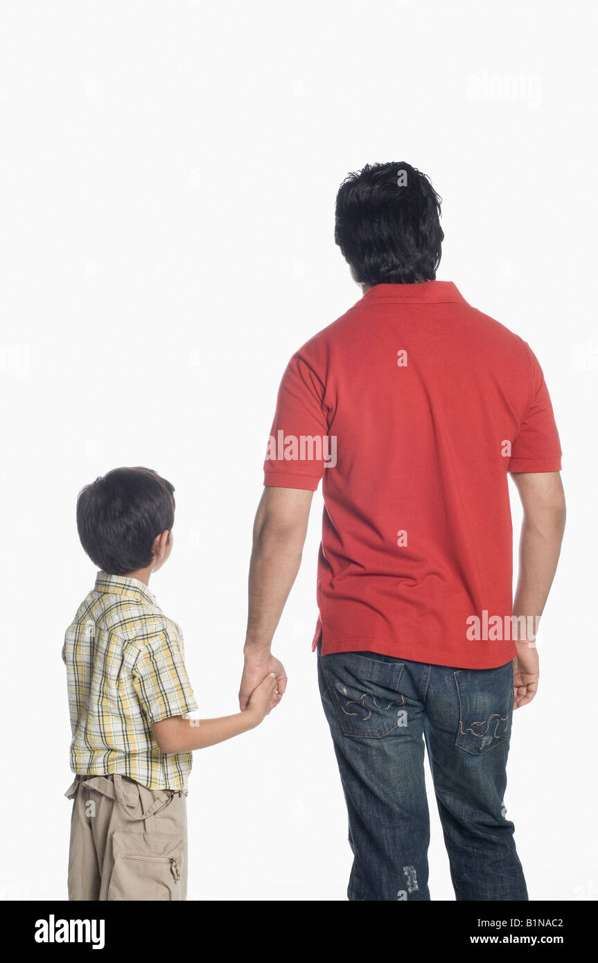 Man boy holding hands rear view Cut Out Stock Images & Pictures - Alamy