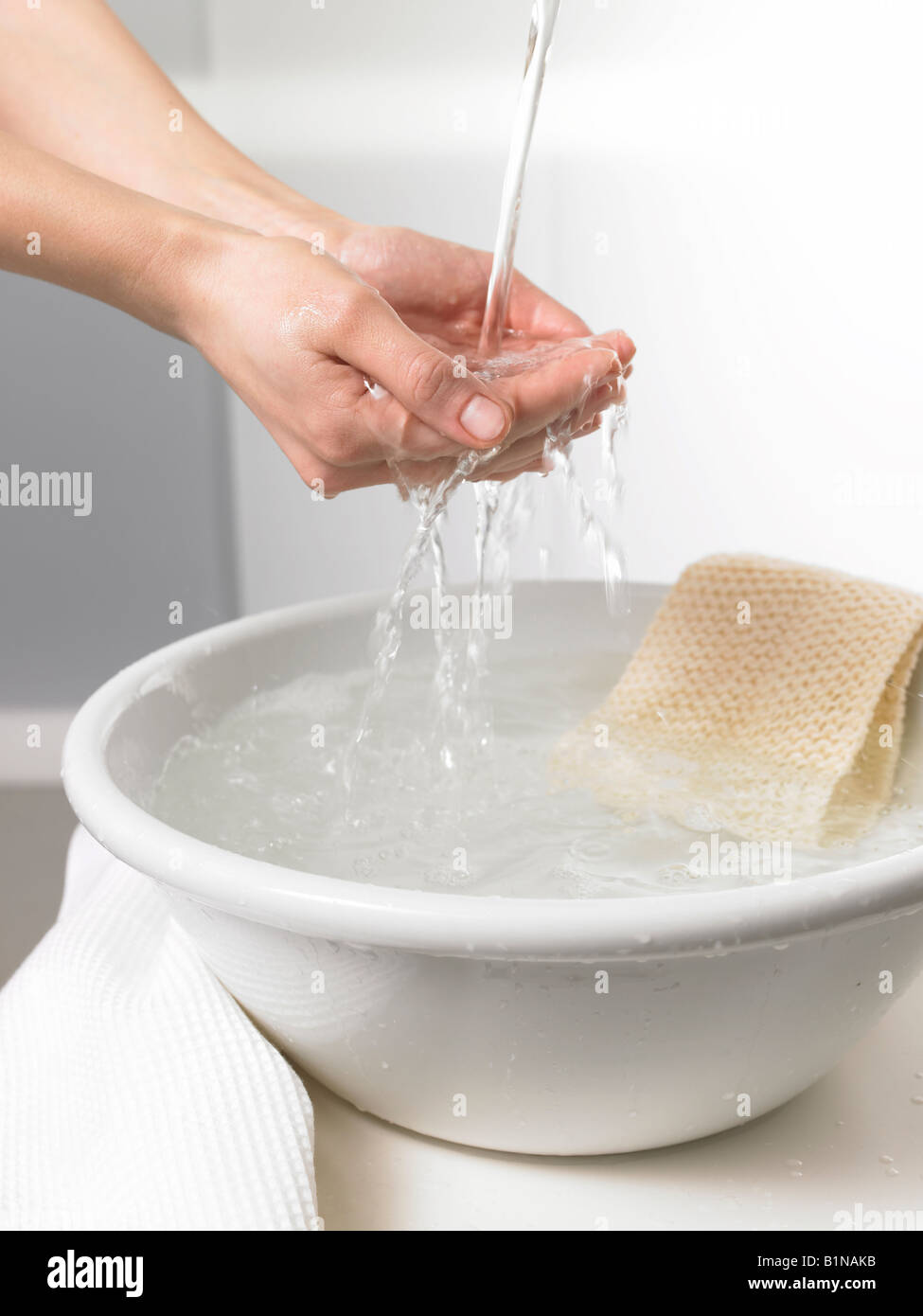 Water is running through hands into a washbowl Stock Photo - Alamy