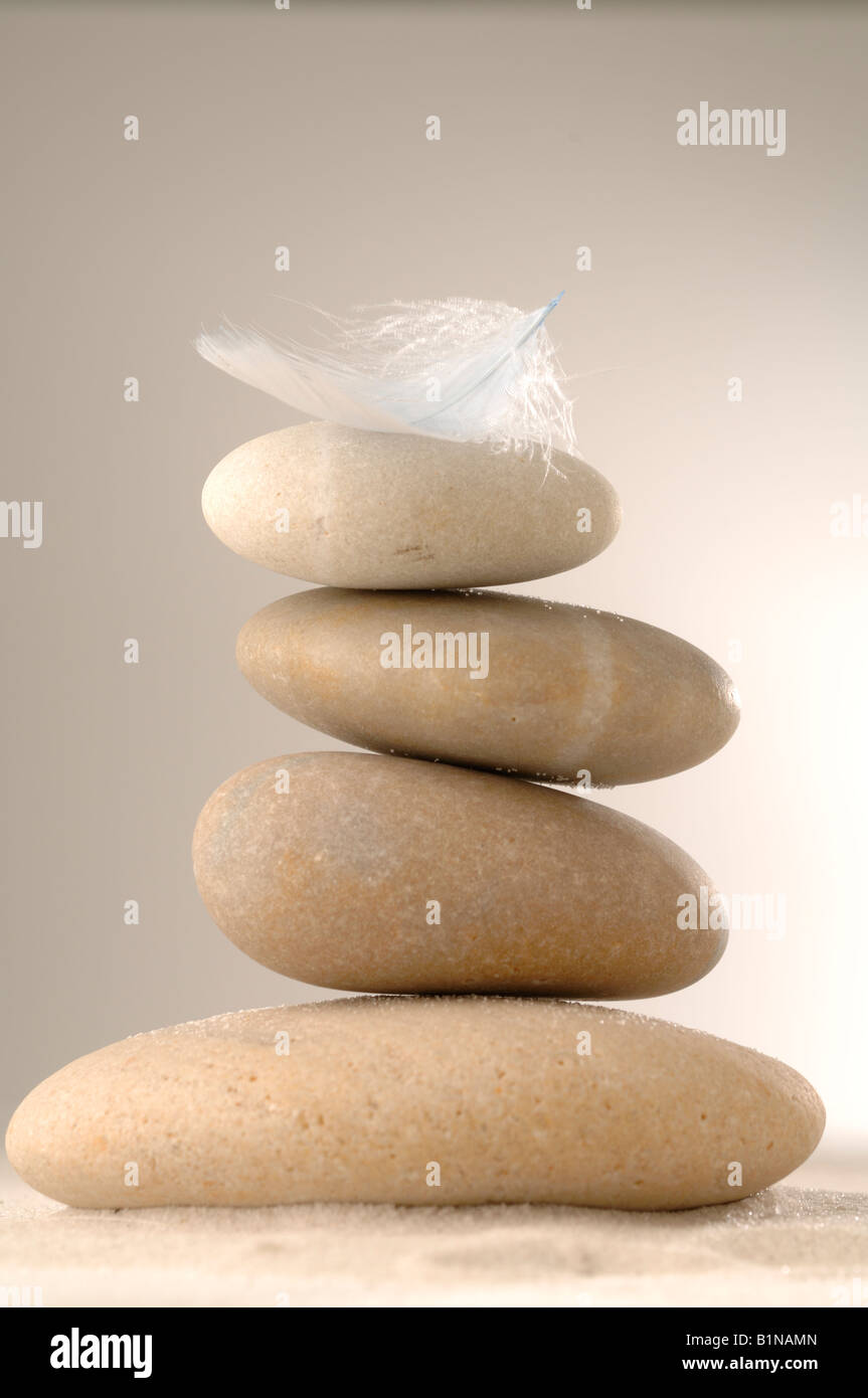 A stack of stones and a feather Stock Photo - Alamy