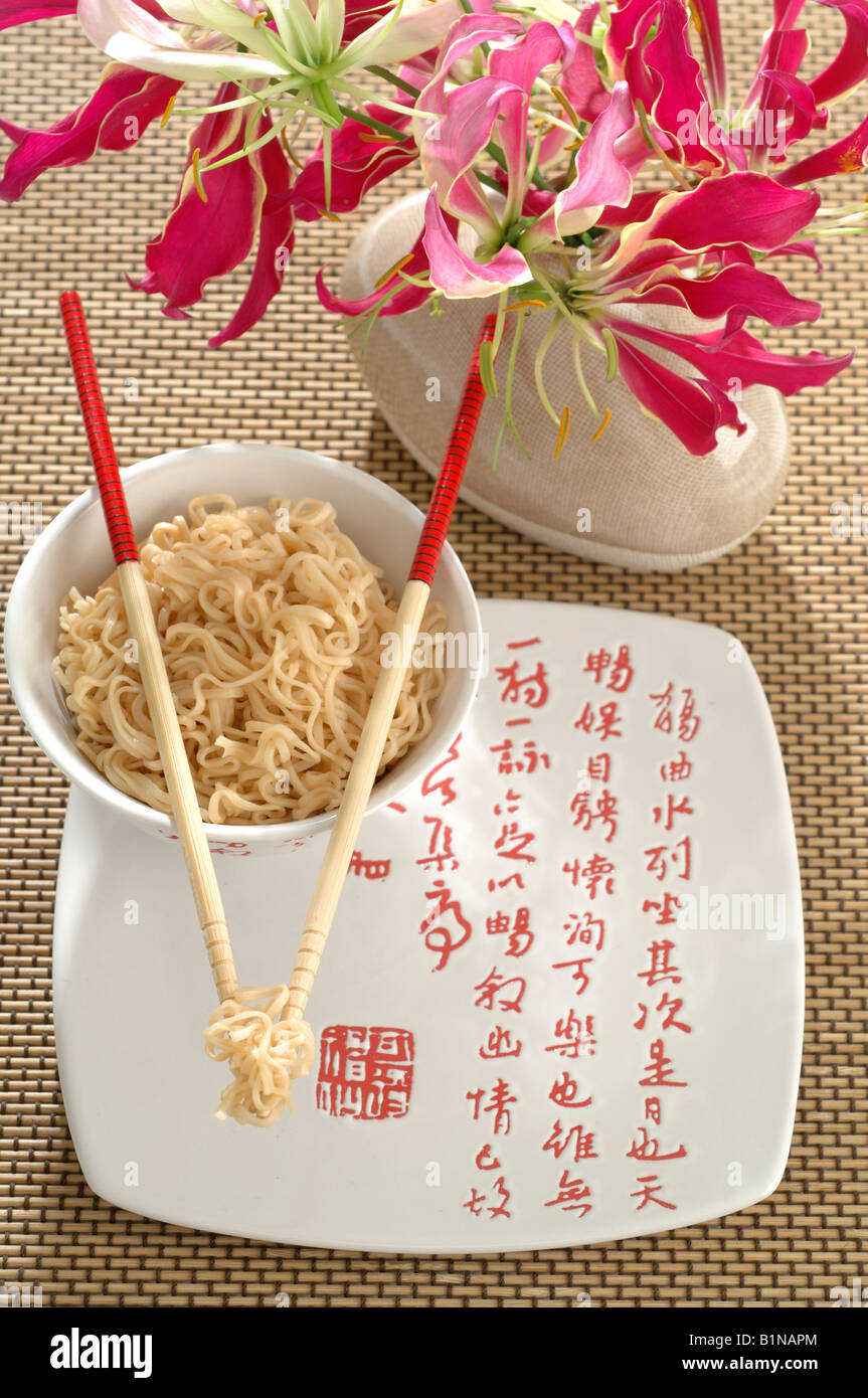 Asian noodles with chopsticks and a flower Stock Photo - Alamy