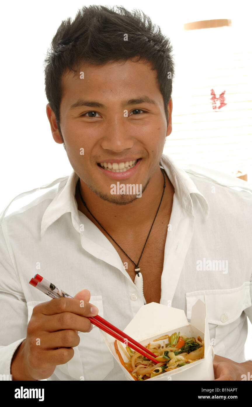 Man is eating an Asian meal in a lunch box with chopsticks Stock Photo ...