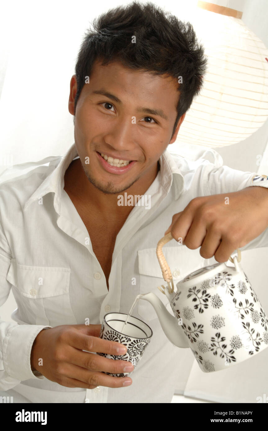 Asian man is pouring tea into a teacup Stock Photo - Alamy