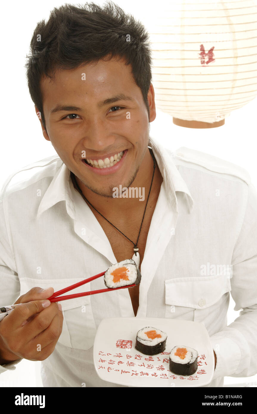 Asian man is eating sushi with chopsticks Stock Photo - Alamy