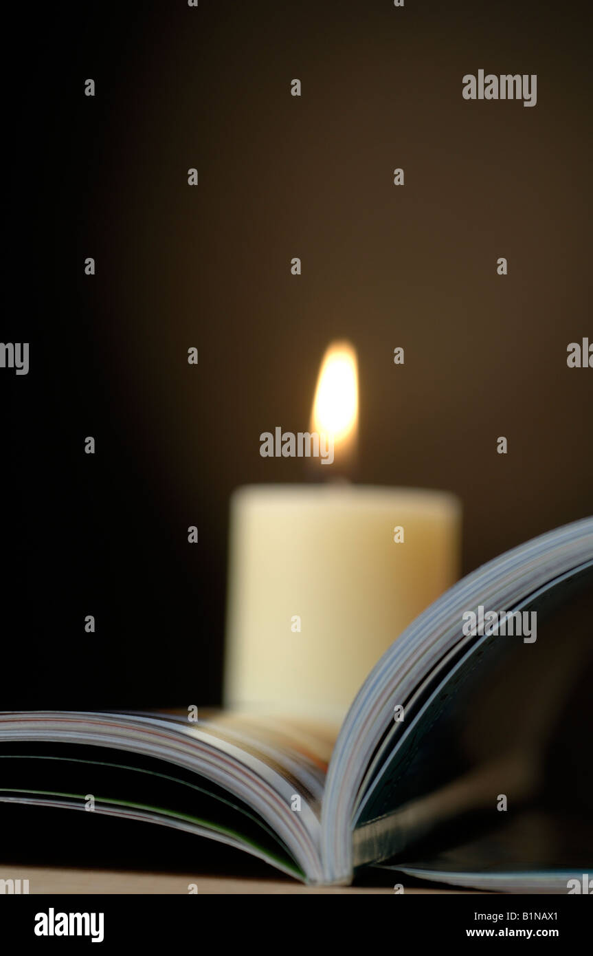 Open book with a candle Stock Photo - Alamy