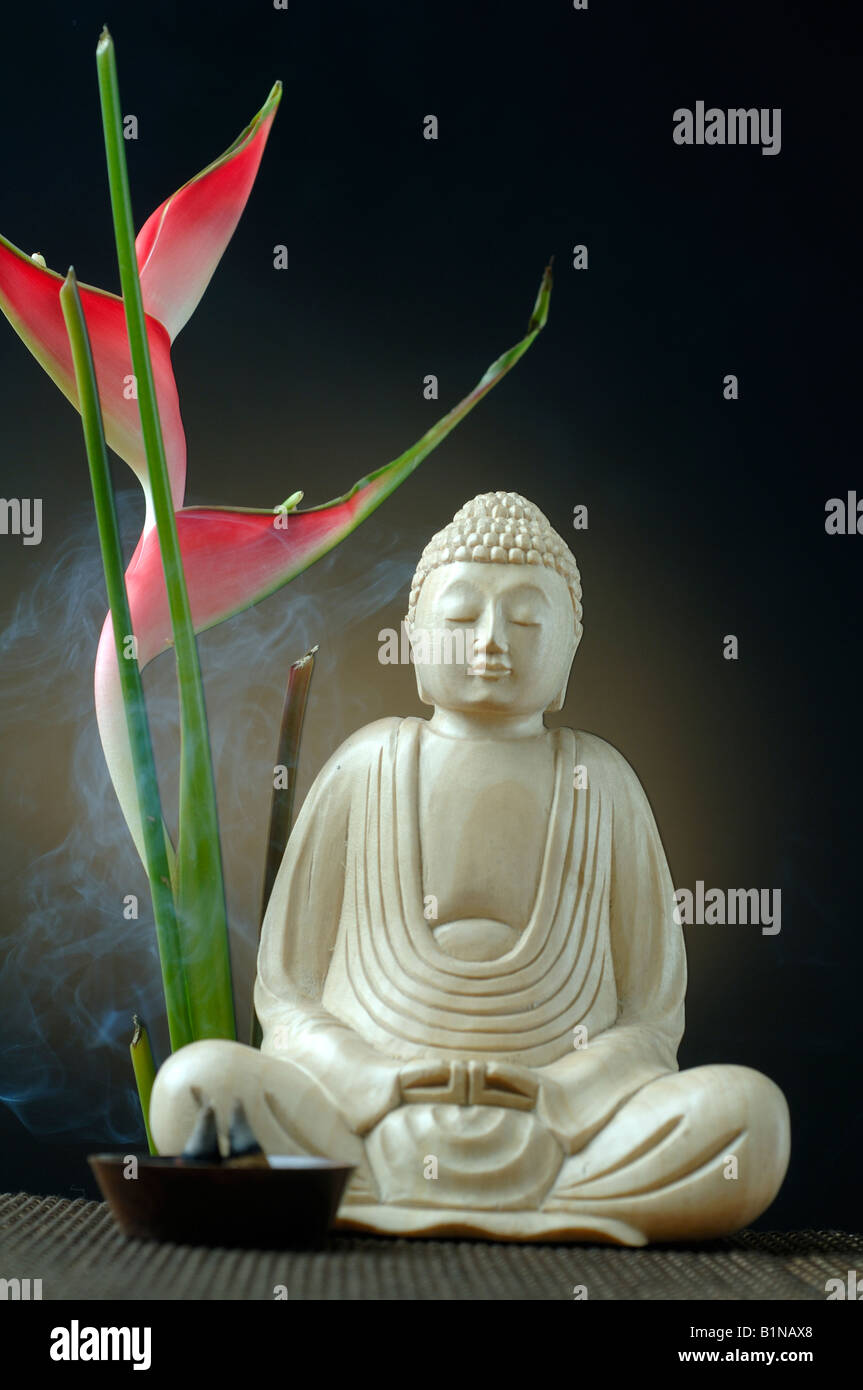Buddha with joss sticks and Heleconia Stock Photo - Alamy