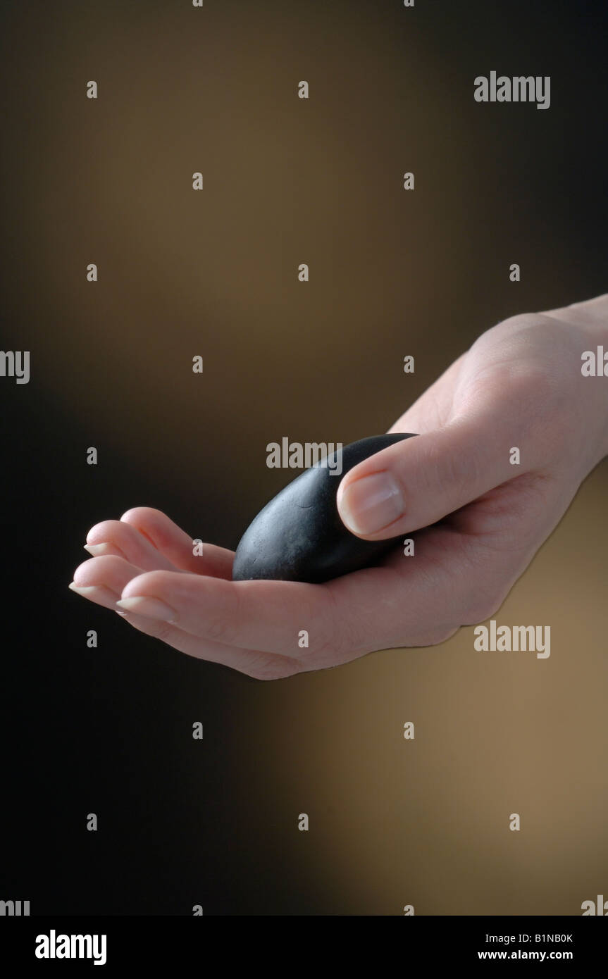 Hand is holding a black stone Stock Photo - Alamy