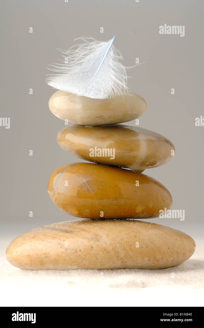 A stack of stones and a feather Stock Photo - Alamy