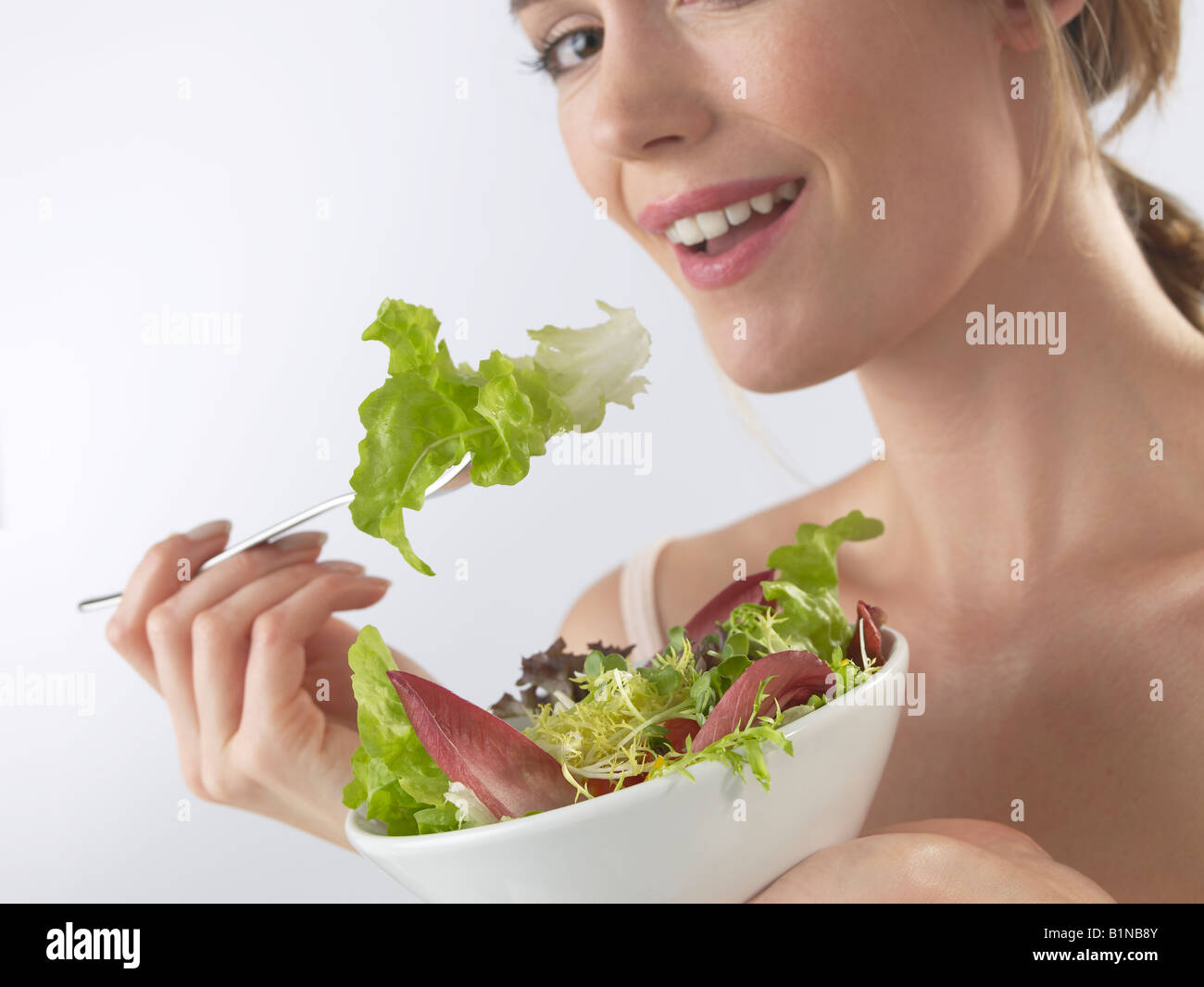 Woman is eating salad Stock Photo - Alamy