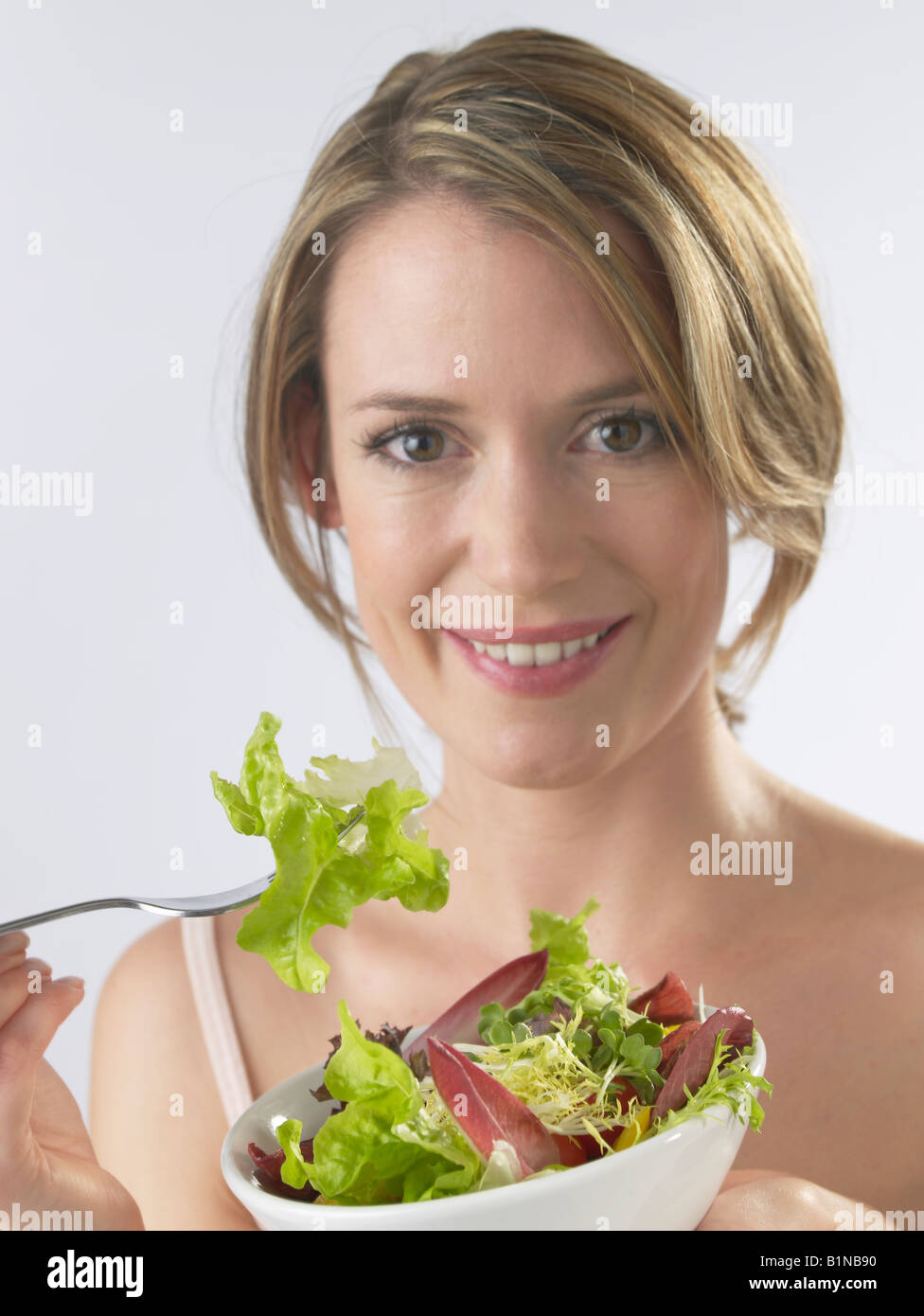 Woman is eating salad Stock Photo - Alamy
