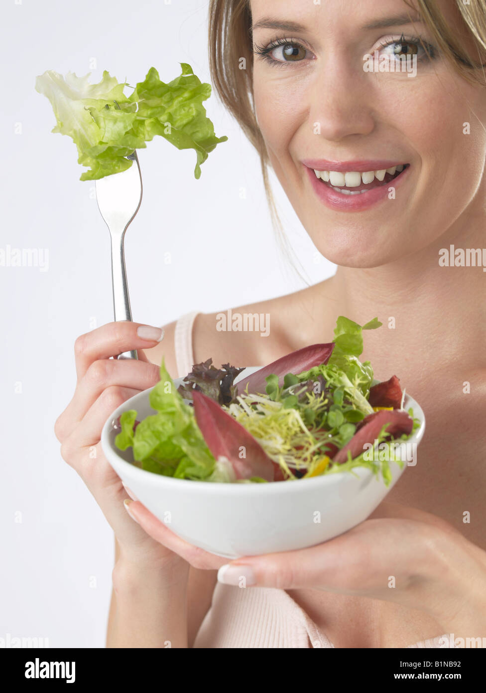 Woman is eating salad Stock Photo - Alamy