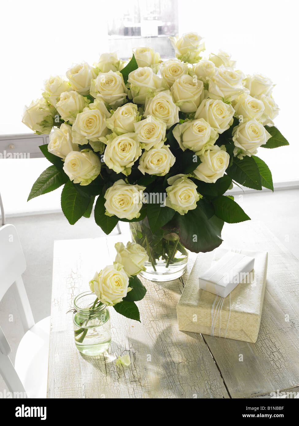 Bouquet of white roses and gifts Stock Photo - Alamy