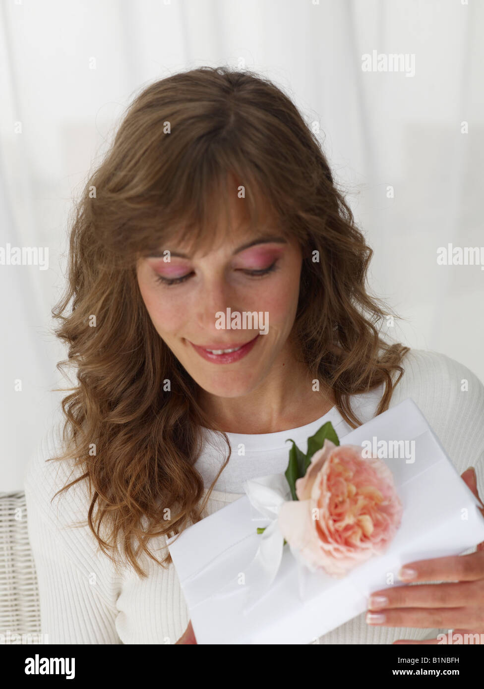 Woman with a white wrapped gift Stock Photo - Alamy